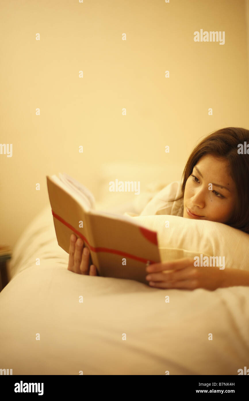 Woman reading book in bedroom hi-res stock photography and images - Alamy