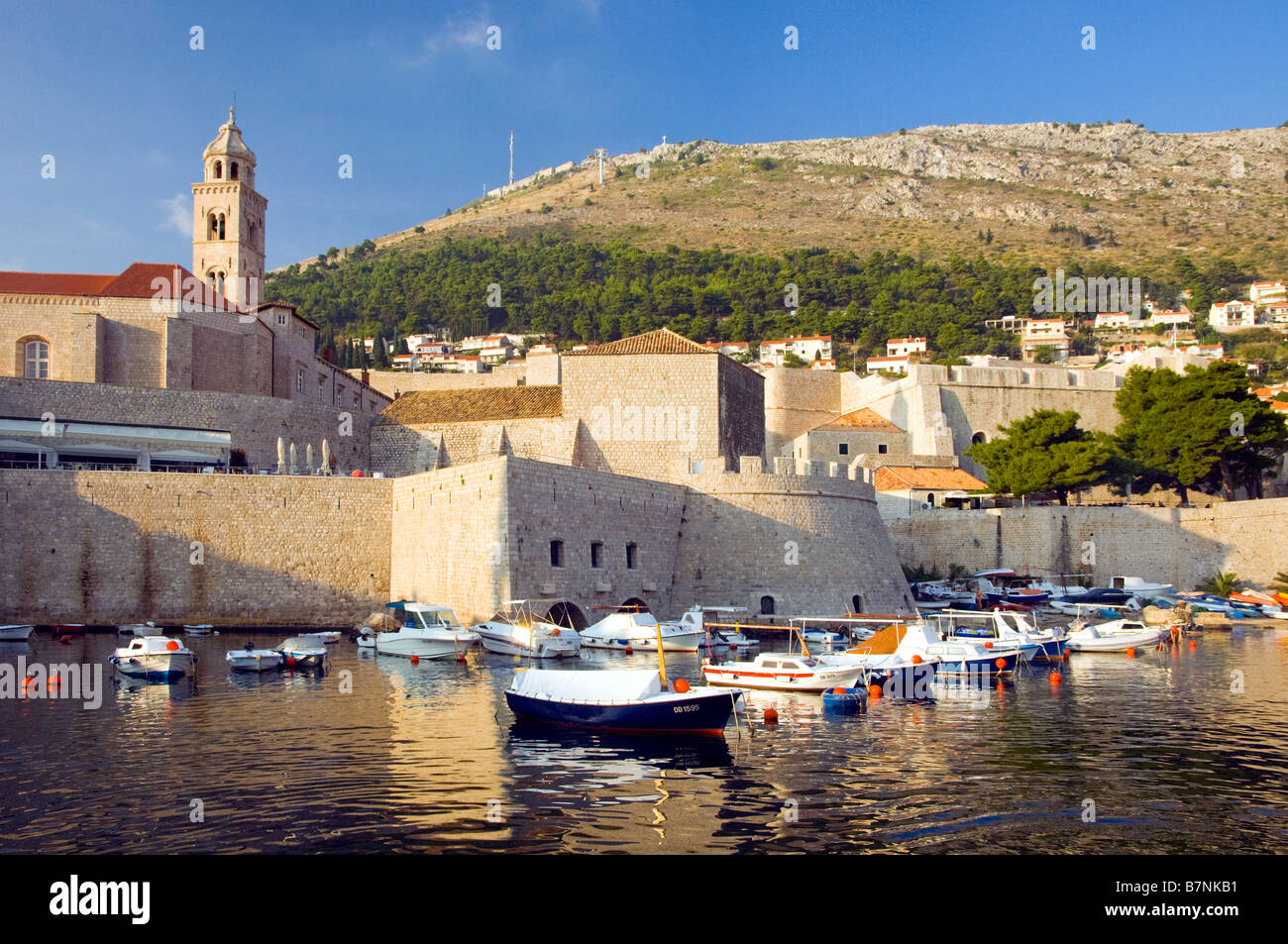 Colorful boats in the small harbour outside the walls of the old city ...