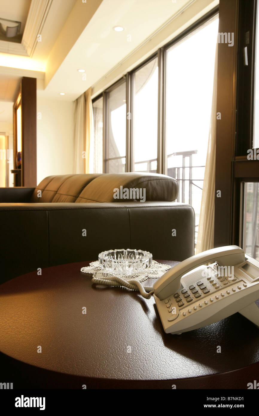 Telephone on table by sofa in living room Stock Photo - Alamy