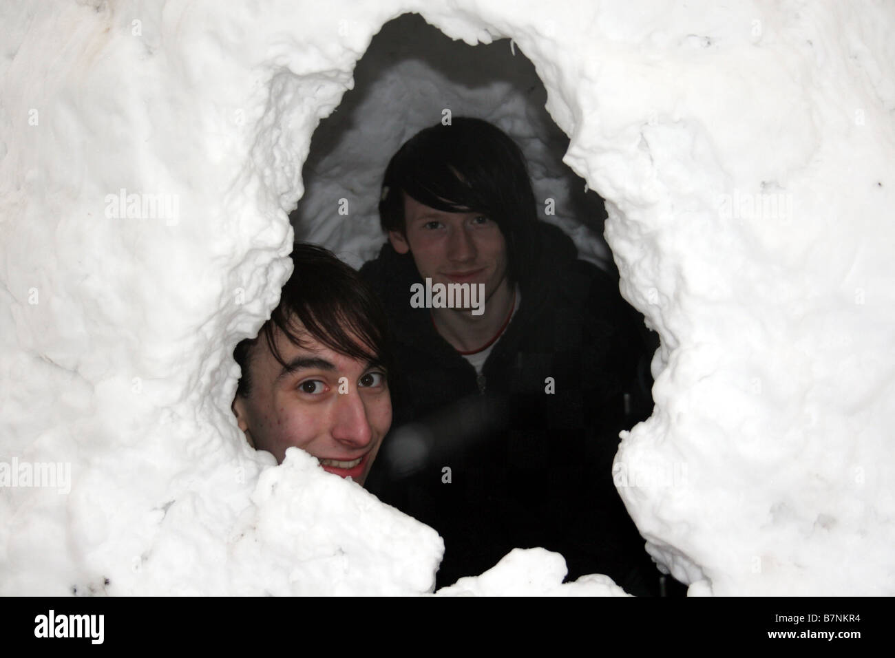 Two men looking through a window of a homemade Igloo in St James Park ...