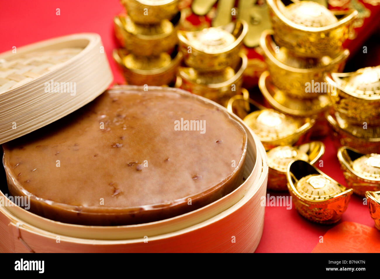 Chinese rice cake by bowls full of gold coins close up Stock Photo - Alamy