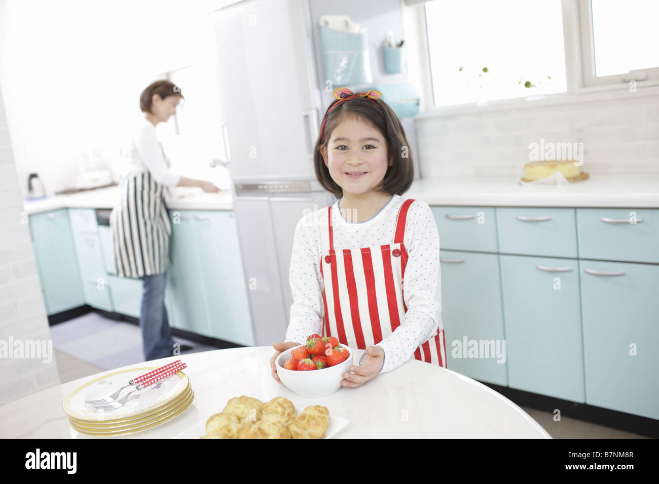A girl helping mother Stock Photo - Alamy