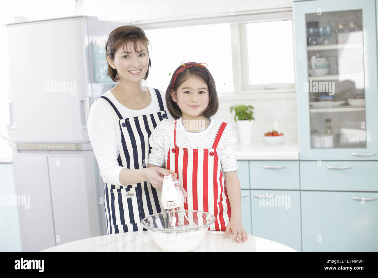 A girl helping mother Stock Photo - Alamy