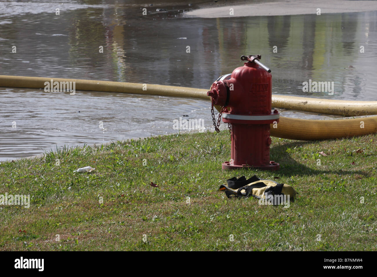 Water flooding the street in front of a fire hydrant with large hose ...