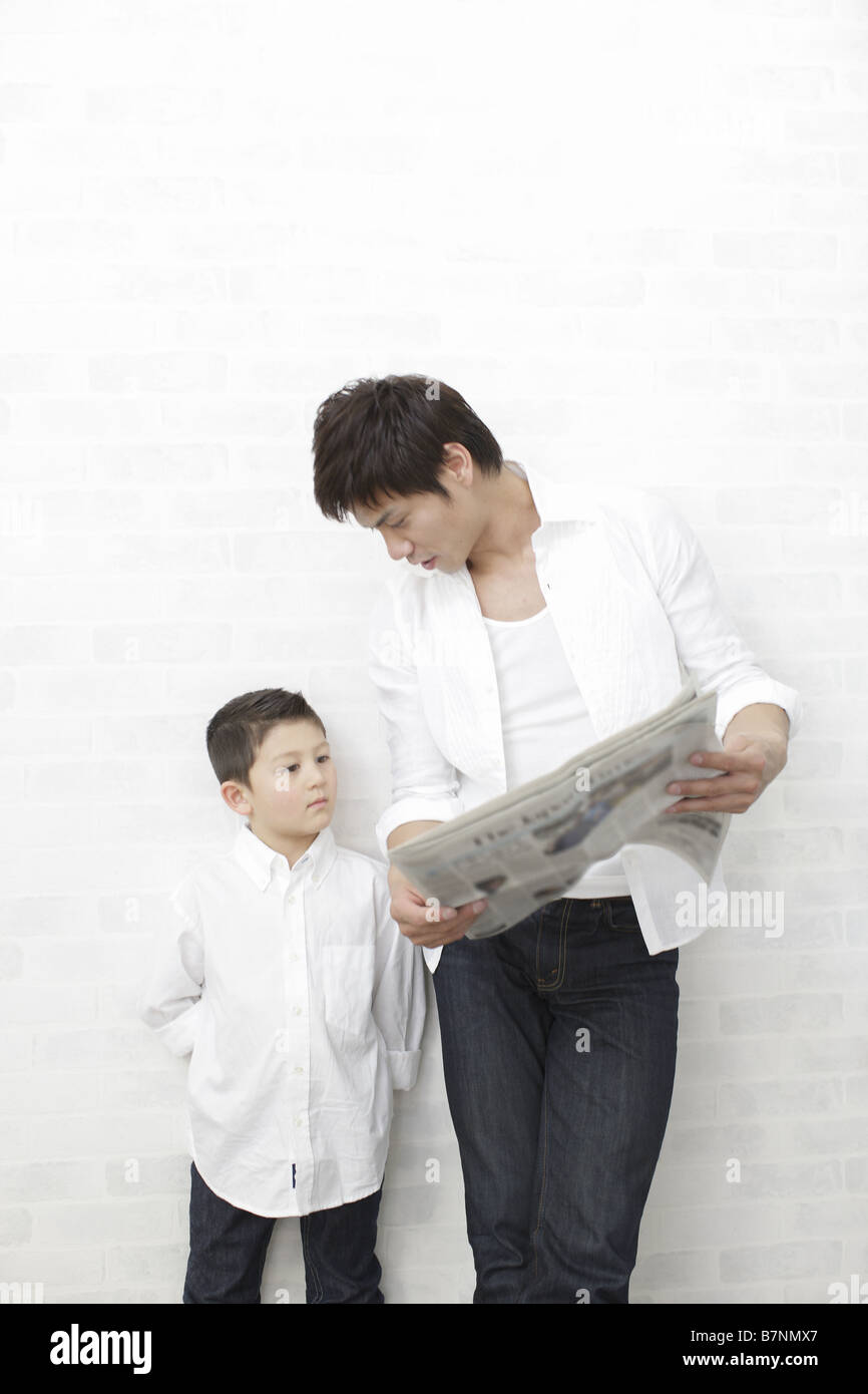 Father and son reading newspaper Stock Photo - Alamy