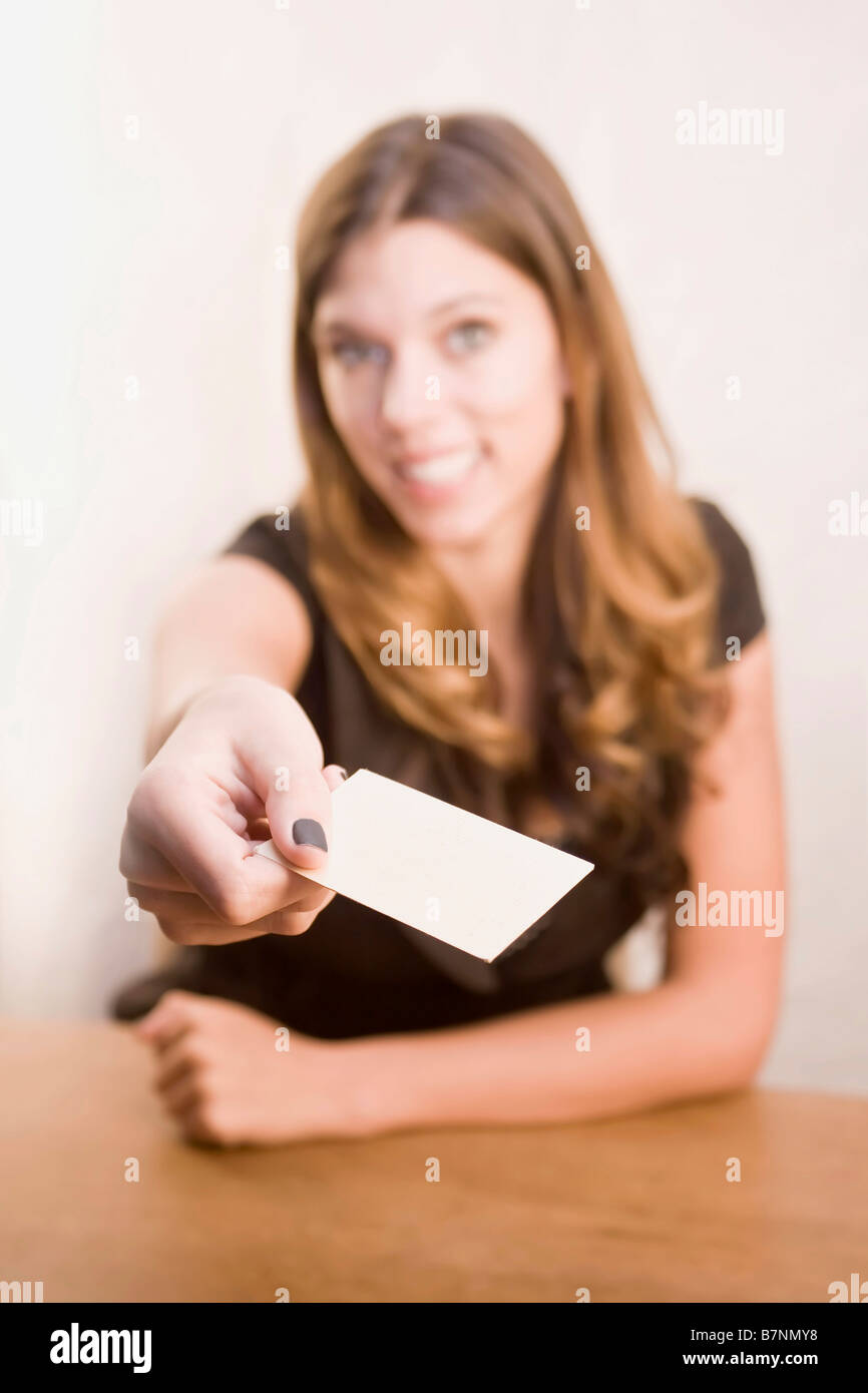 A young woman giving over her business card Stock Photo - Alamy