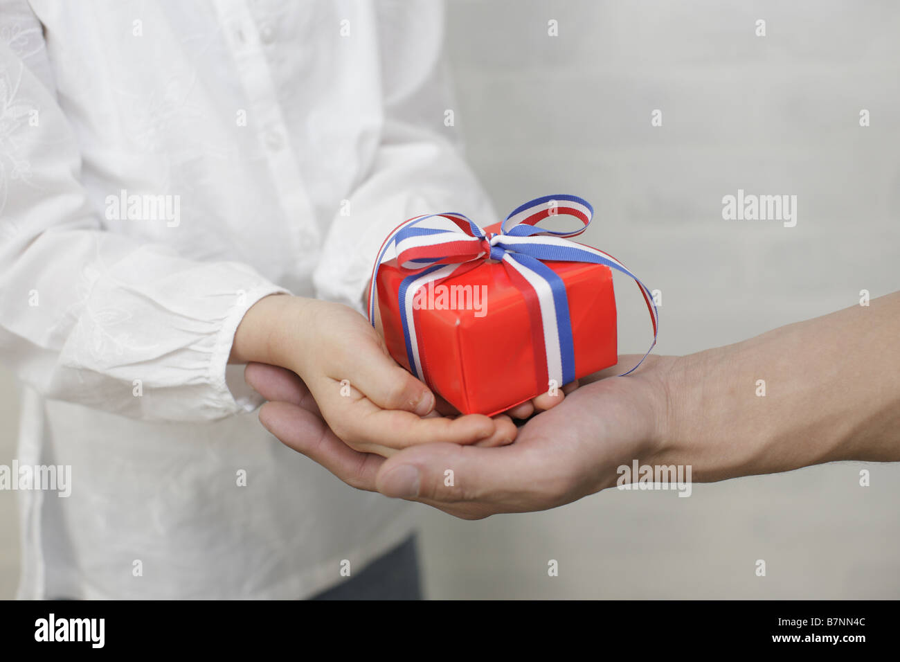 Hand is holding a gift box with a red ribbon hi-res stock photography and images - Alamy