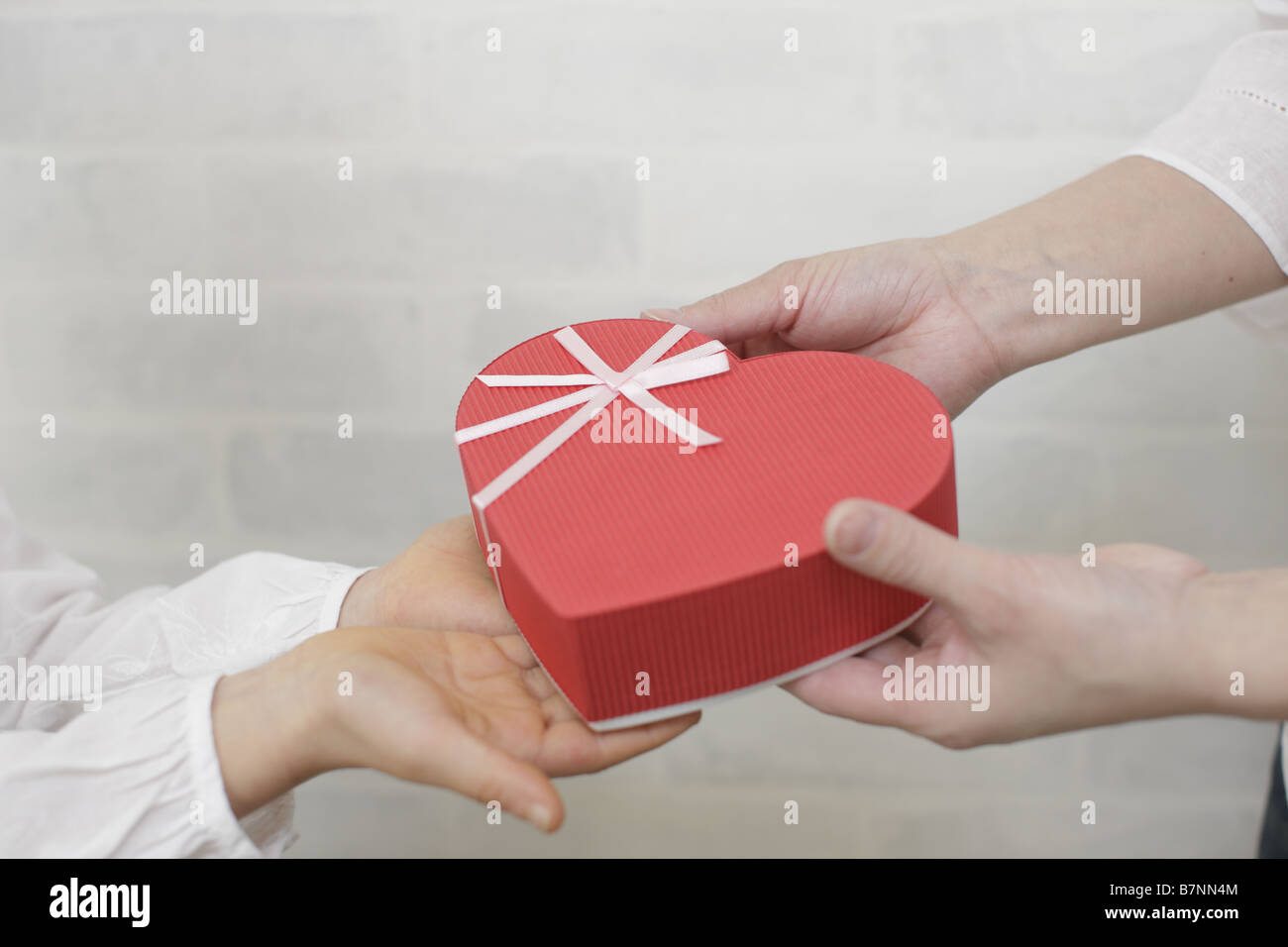 Hand is holding a gift box with a red ribbon hi-res stock photography and images - Alamy