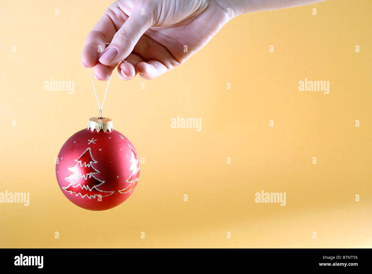 Red ball in a girl hand isolated on yellow Stock Photo - Alamy
