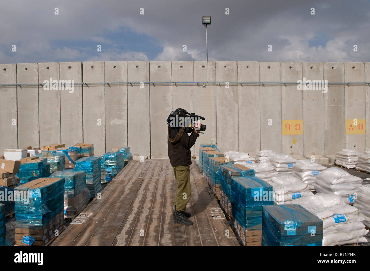 An Israeli soldier filming sacks of food donated by UNRWA and WFP ...