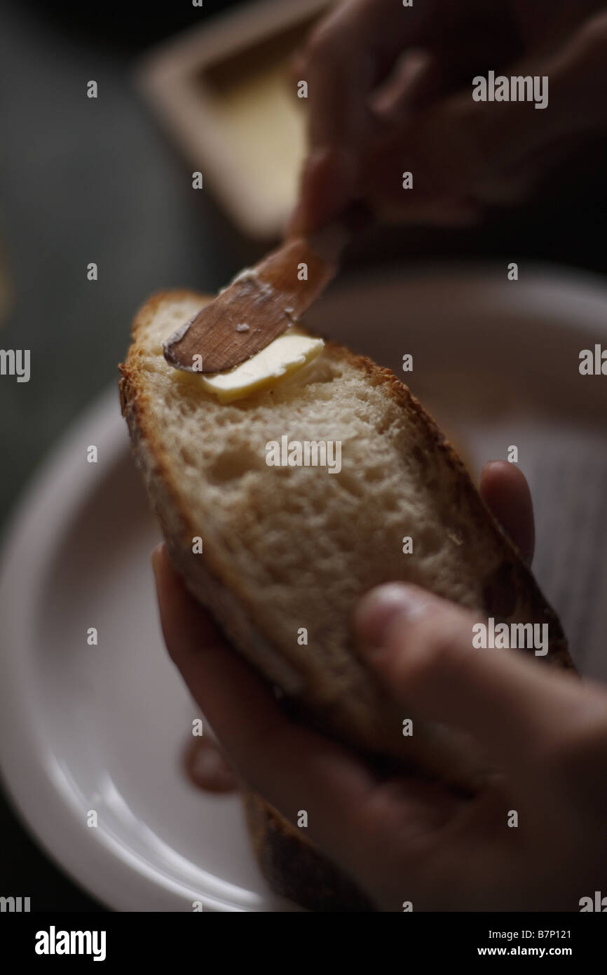 Spreading bread with butter Stock Photo - Alamy