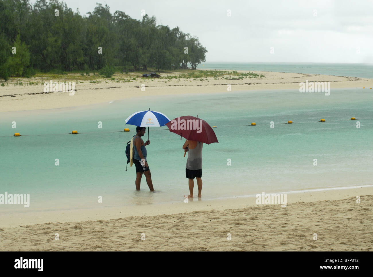 Tourists during a short sharp rainfall on the Ile aux Cerfs Mauritius ...