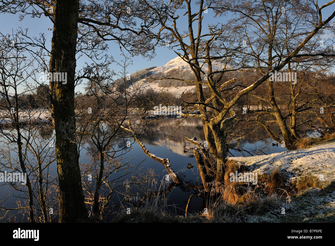View through trees of the River Lochay and distant hills in winter near ...