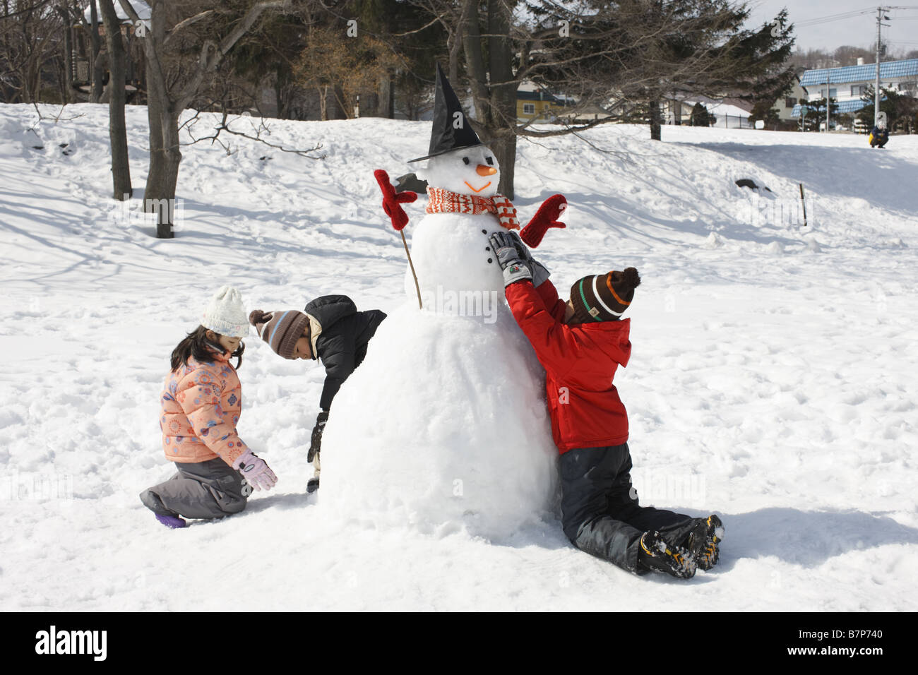 Children making a snowman Stock Photo - Alamy