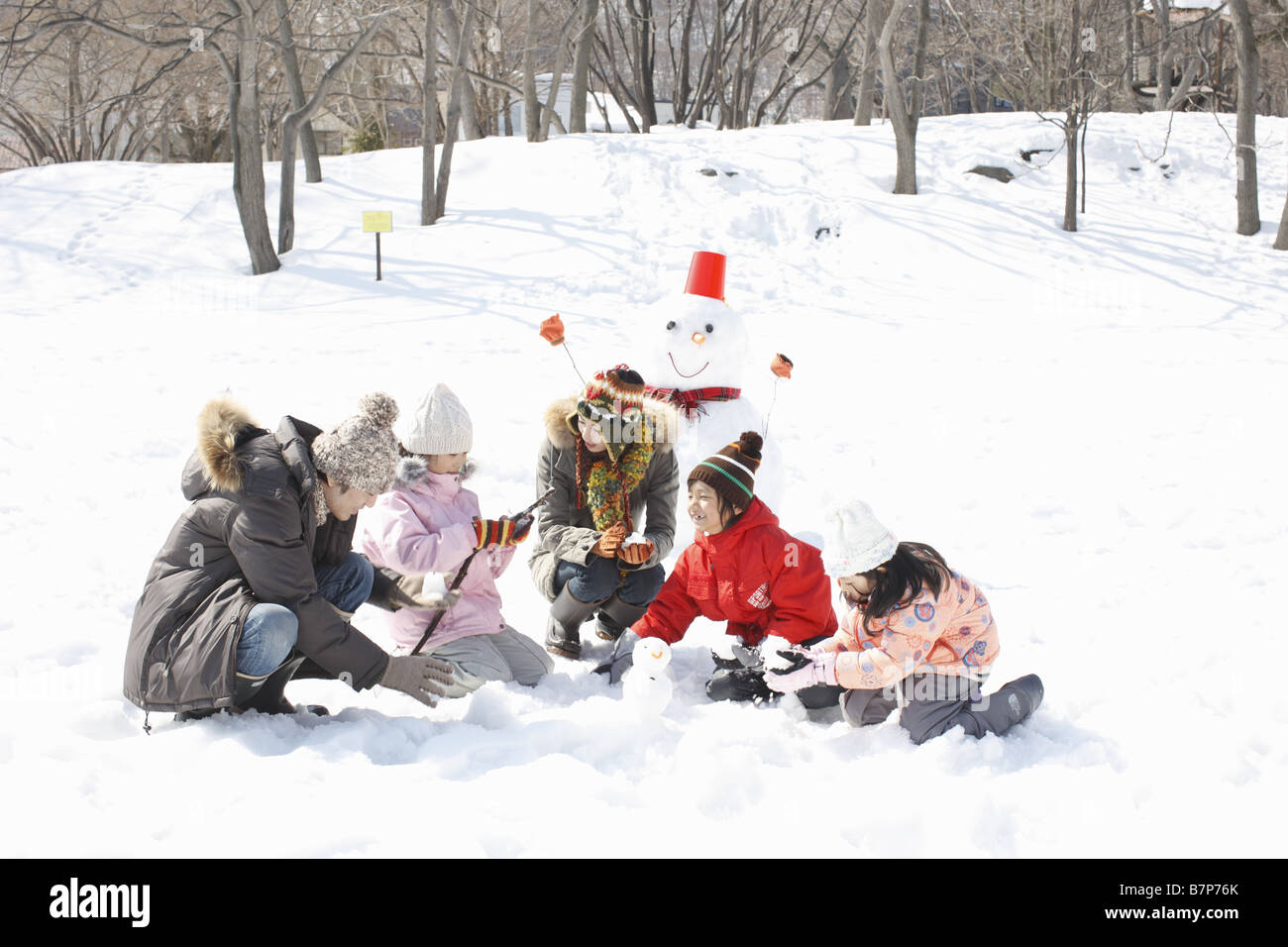Family making a snowman Stock Photo - Alamy