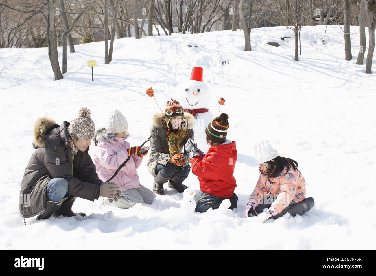 Family making a snowman Stock Photo - Alamy