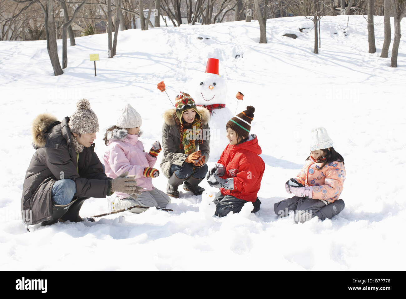 Family making a snowman Stock Photo - Alamy