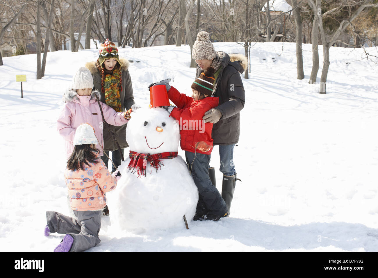 Family making a snowman Stock Photo - Alamy