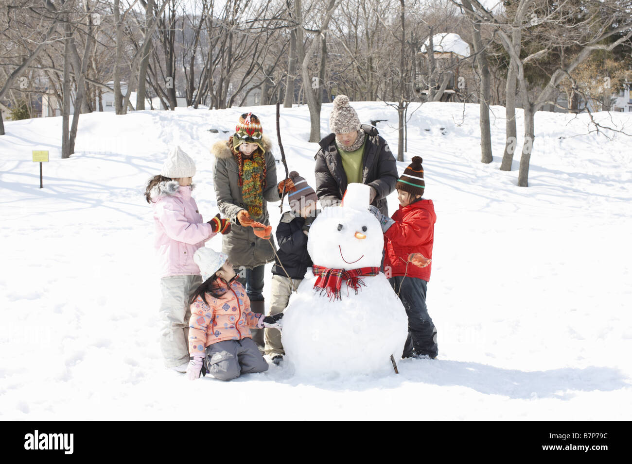 Family making a snowman Stock Photo - Alamy