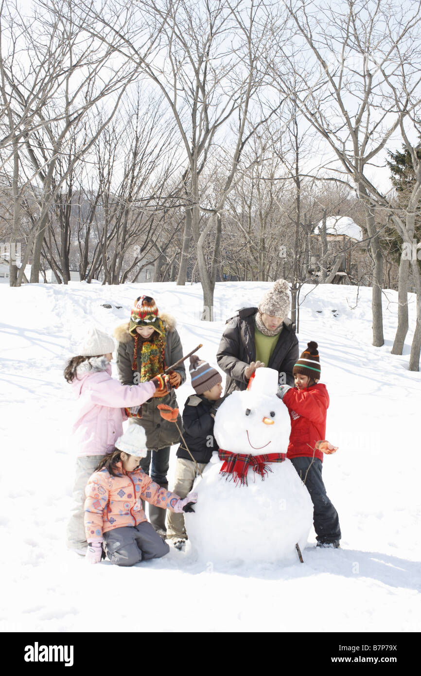 Family making a snowman Stock Photo - Alamy