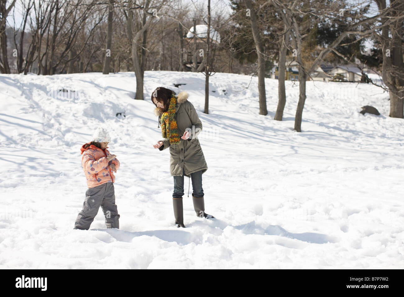Mother and daughter playing in the snow Stock Photo - Alamy