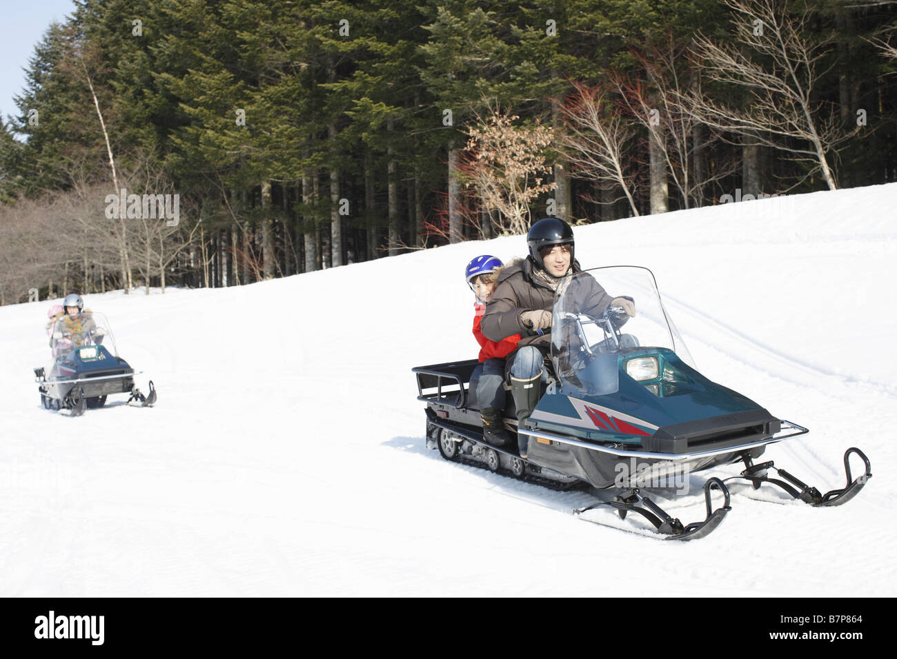 Family riding on snowmobiles Stock Photo - Alamy