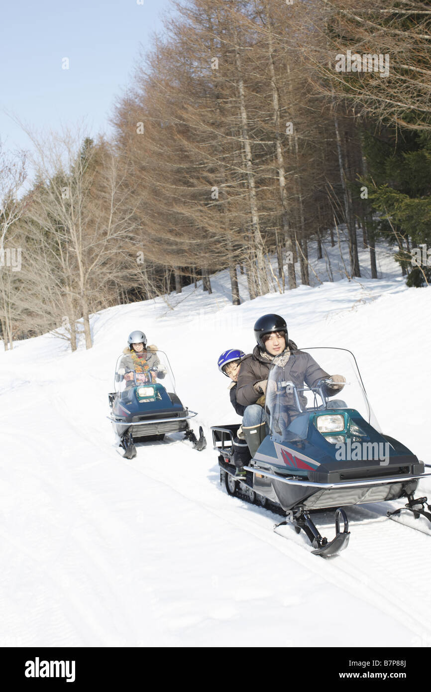 Family riding on snowmobiles Stock Photo - Alamy