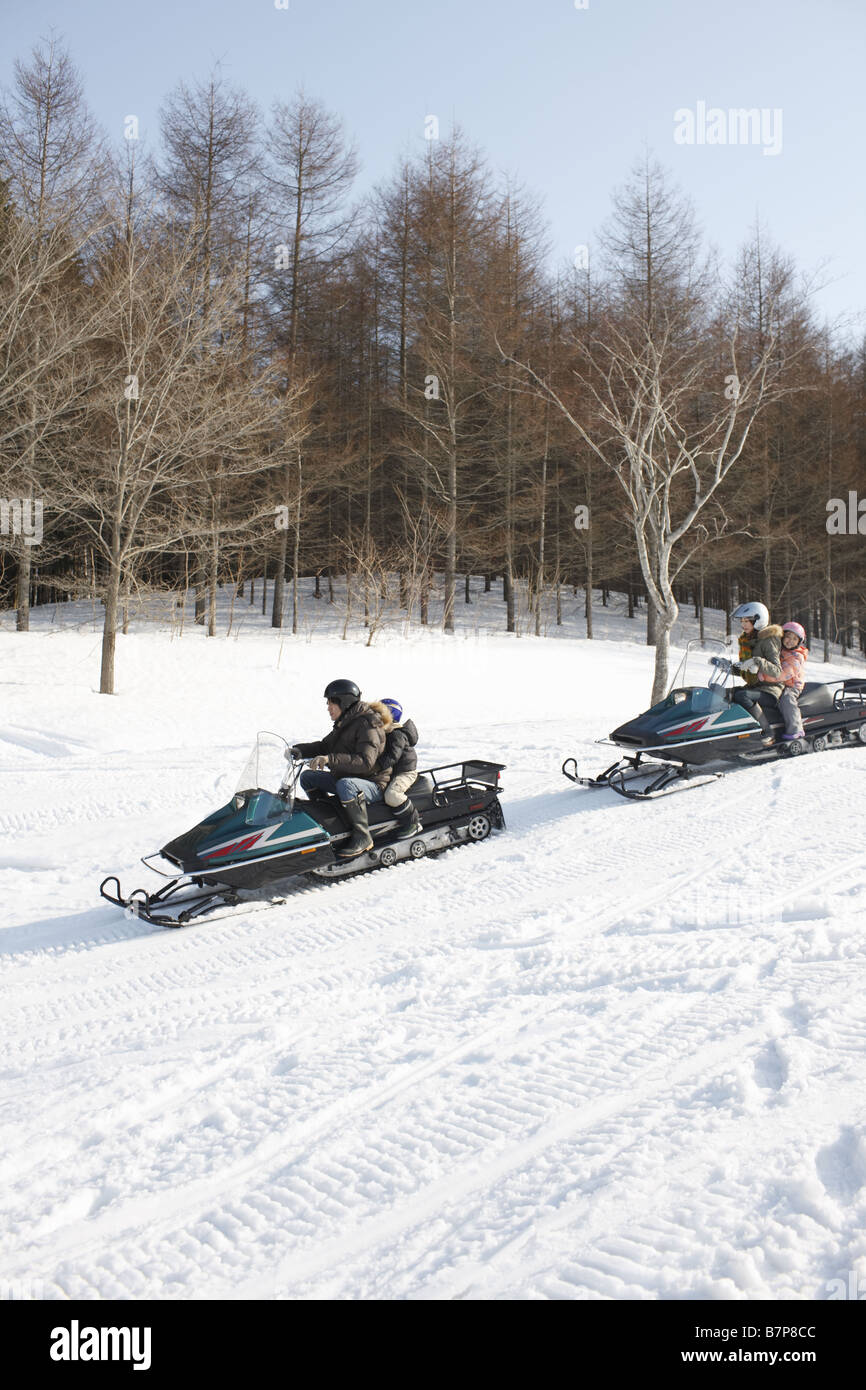 Family riding on snowmobiles Stock Photo - Alamy