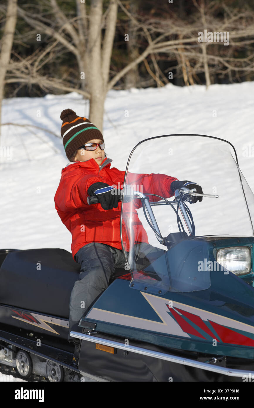 A boy riding on snowmobile Stock Photo - Alamy