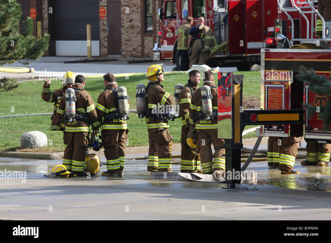 A large group of firefighters at a fire scene, some wearing SCBA ...