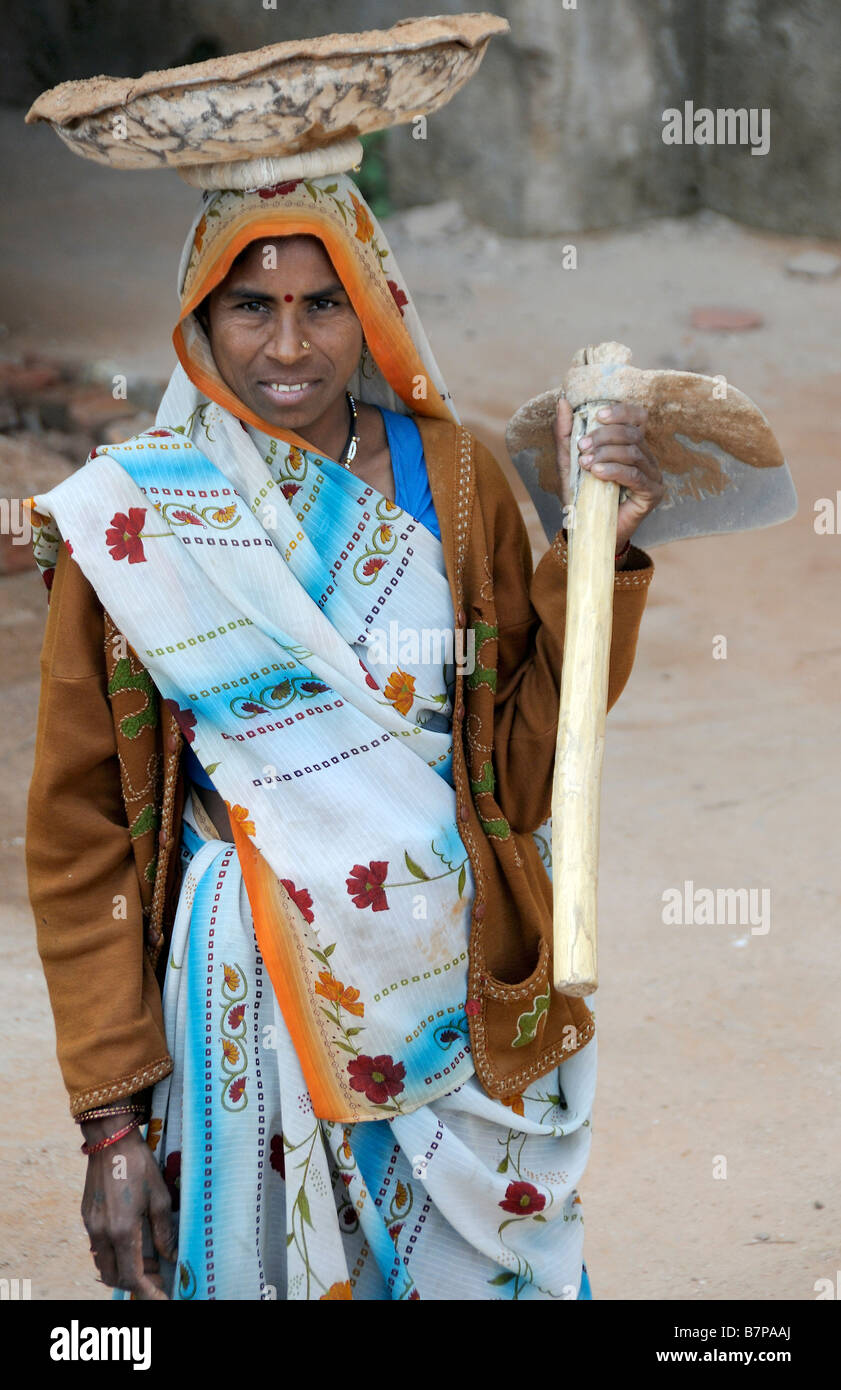 A lady construction worker poses with her digging tool and carrying ...