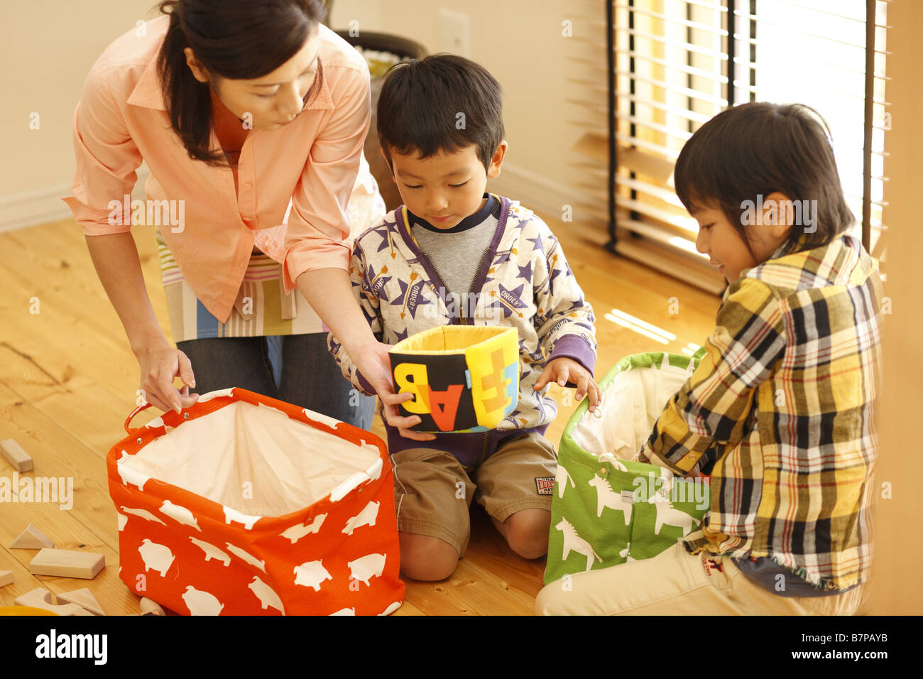 Mother and children putting away Stock Photo - Alamy