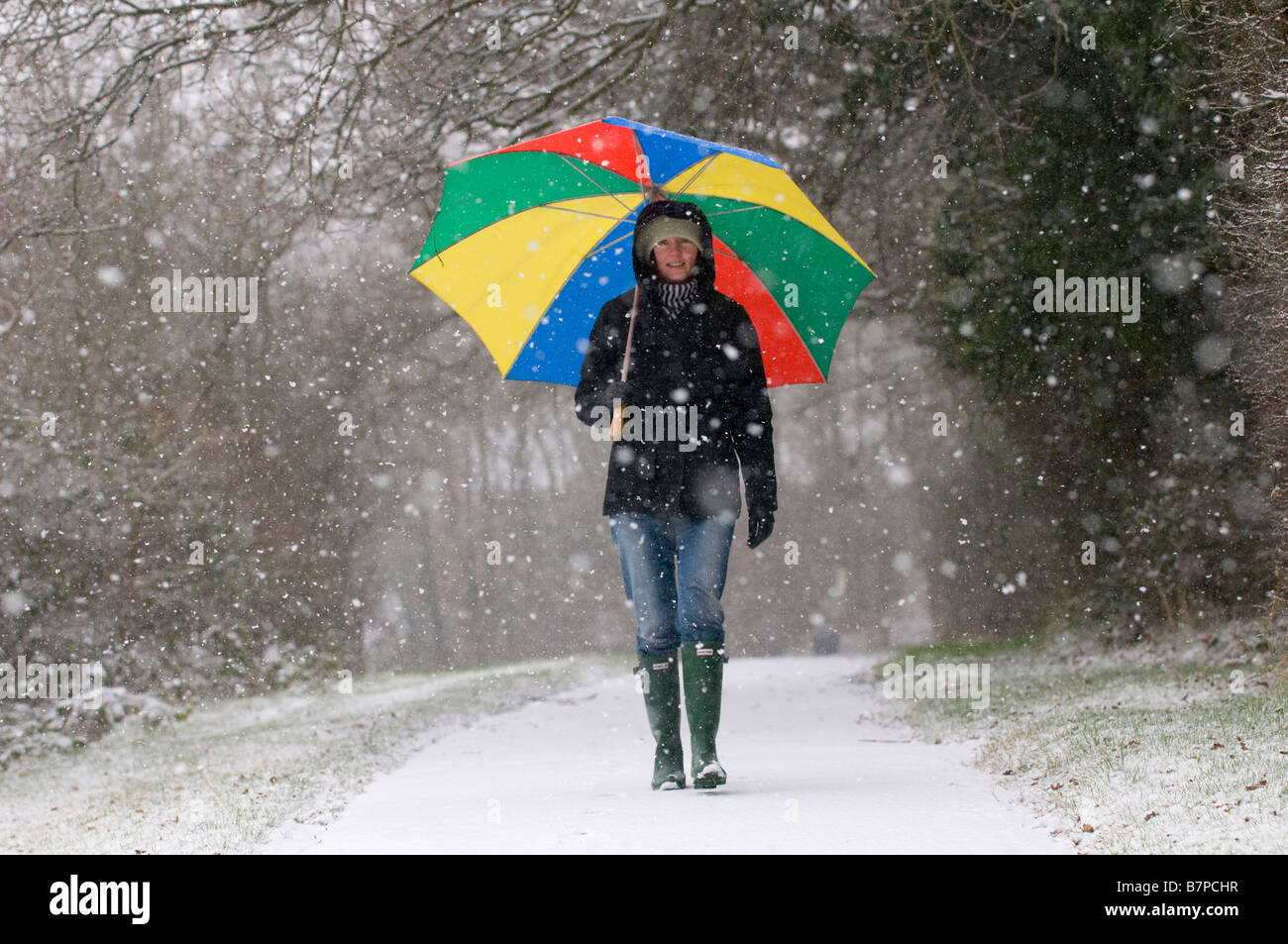 A woman with an umbrella walks through a heavy snow shower in Redditch ...