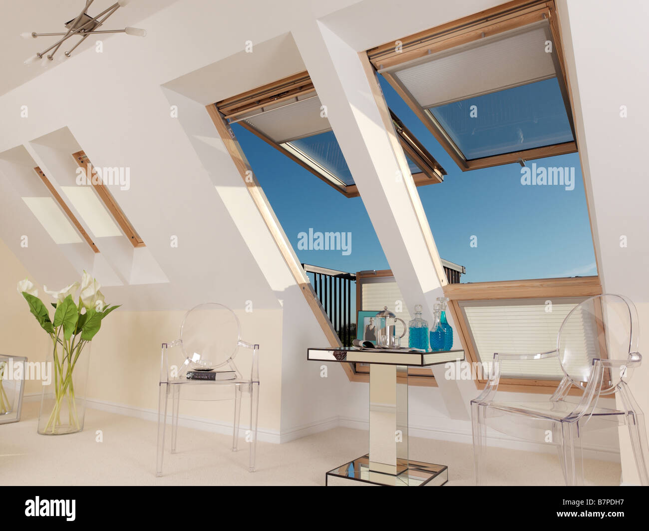 large velux window open with blind and blue sky with table and chairs ...