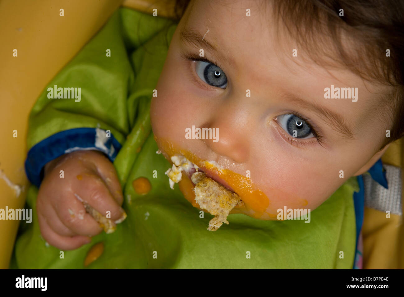 A baby girl feeding herself Stock Photo - Alamy