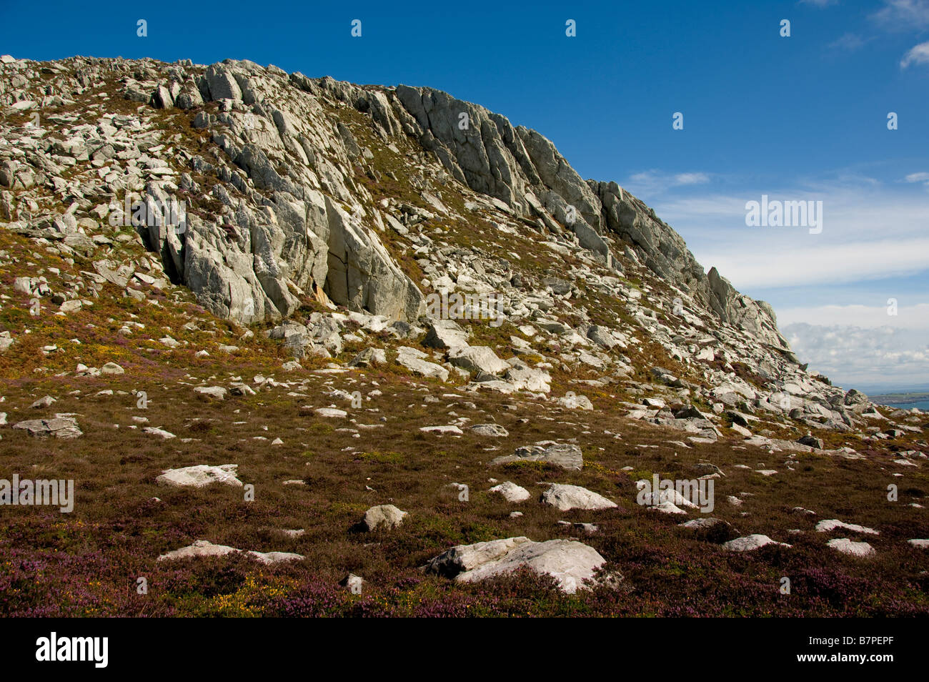 Holyhead mountain on Holy Island, Anglesey, seen against a blue sky on ...