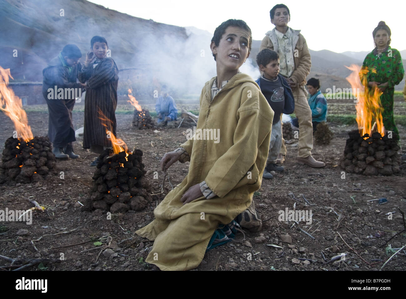 Children stand beside fire pits Stock Photo - Alamy