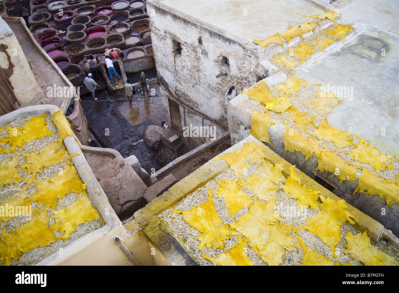 Men work in red dyeing pits at a leather tannery in Fes El-Bali ...