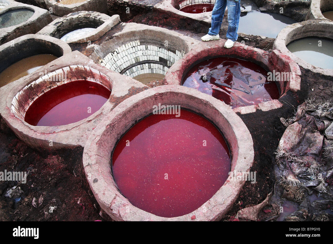 A young man stands on the edge of colorful red dyeing pits Stock Photo ...