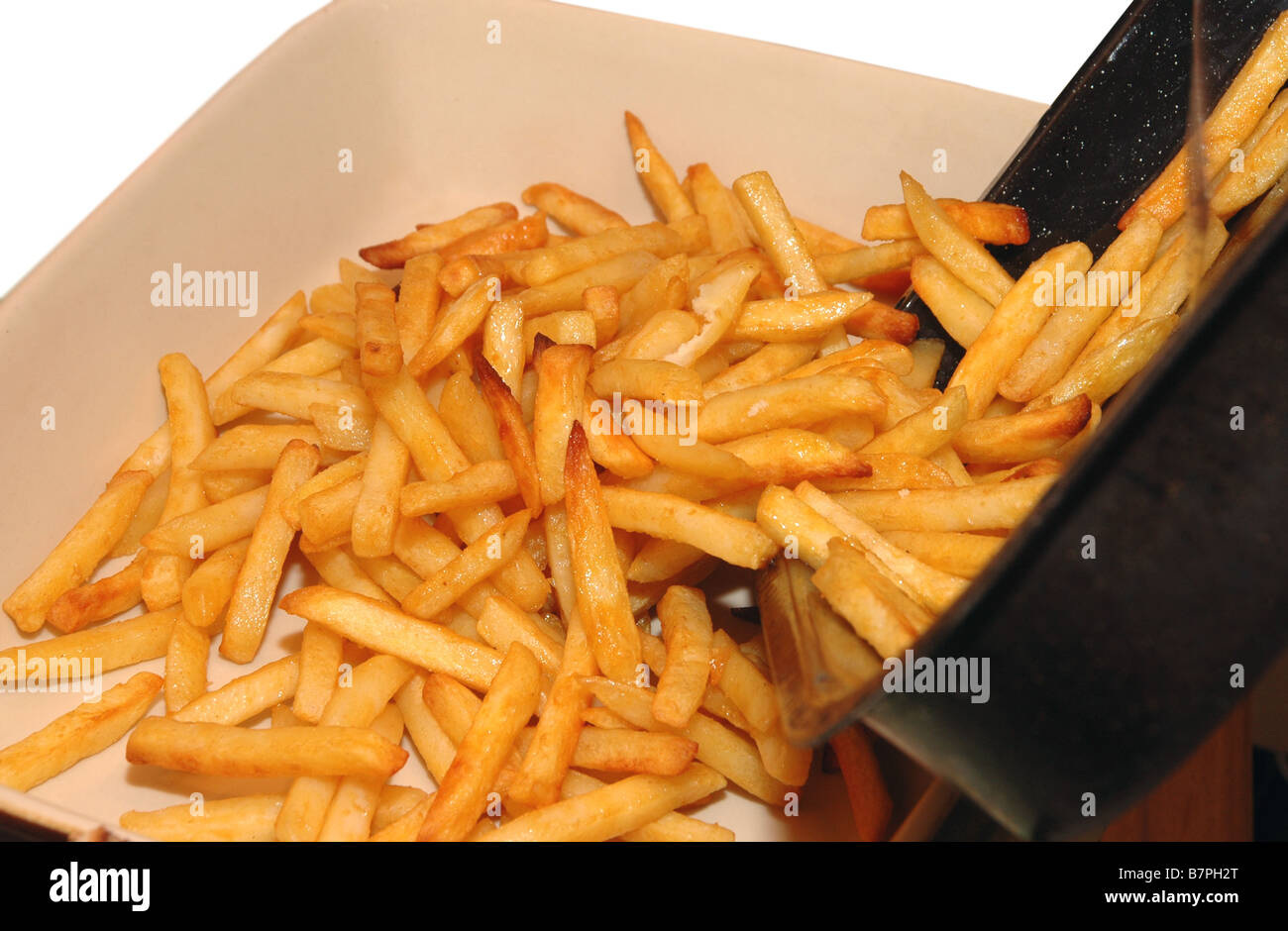 Oven chips being placed in a serving dish Stock Photo - Alamy