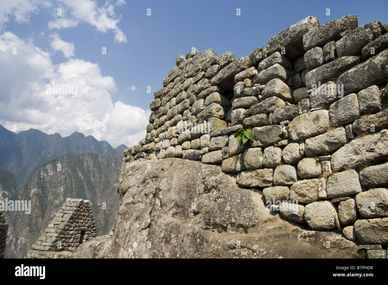 A stone wall still stands, built by the Inca to fit over a naturally ...