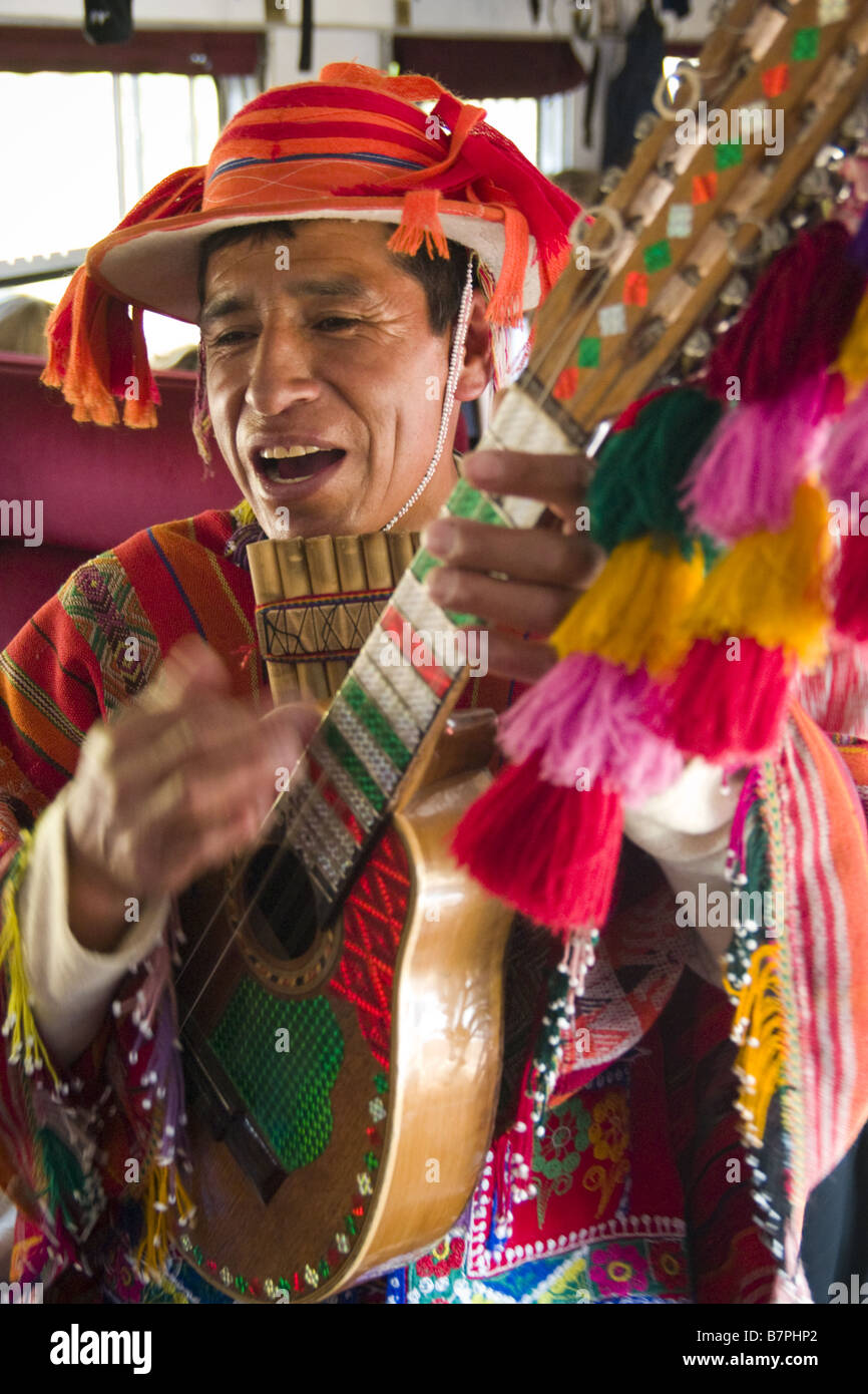 A musician performs Andean music for tourists inside the train from ...