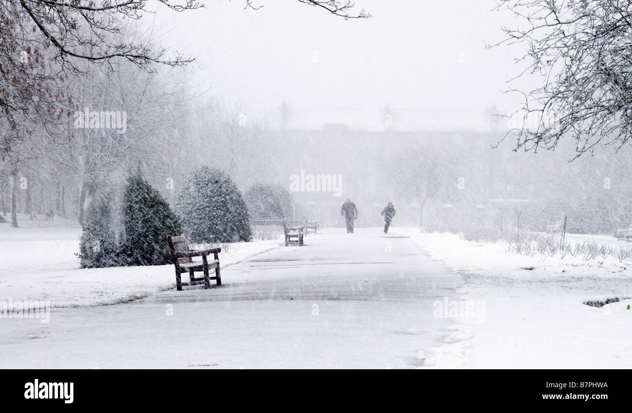 two people happily strolling in a snowy park during snow storm Stock ...