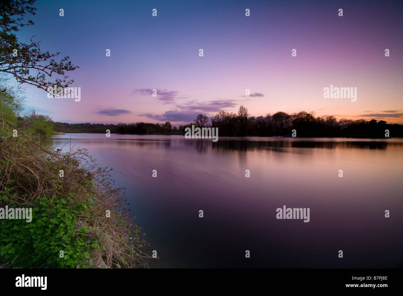 Coate Water Park Swindon Mirrored horizon with deep sunset to sky Stock ...