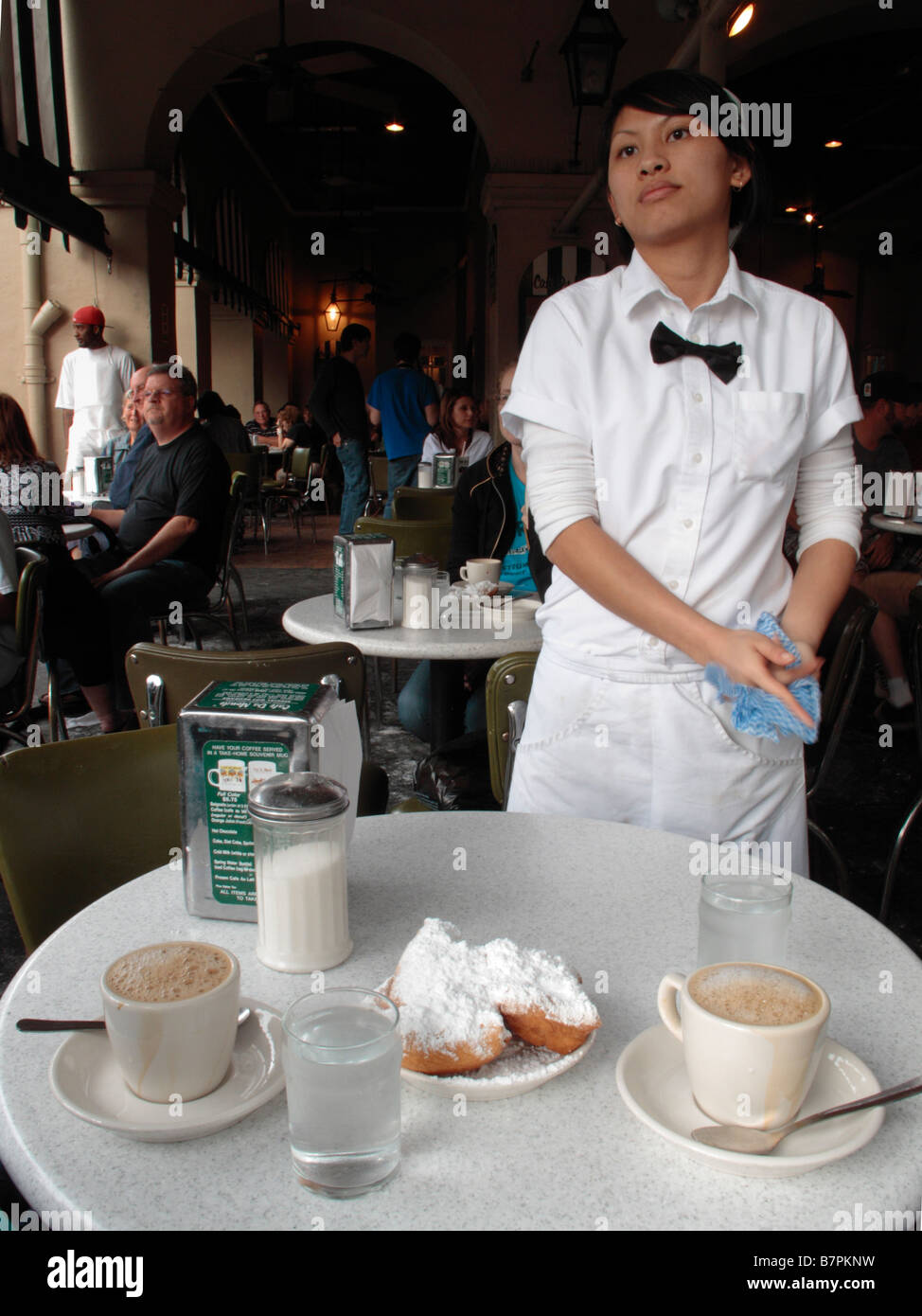 Waitress serving beignets and coffee at Cafe du Monde New Orleans ...