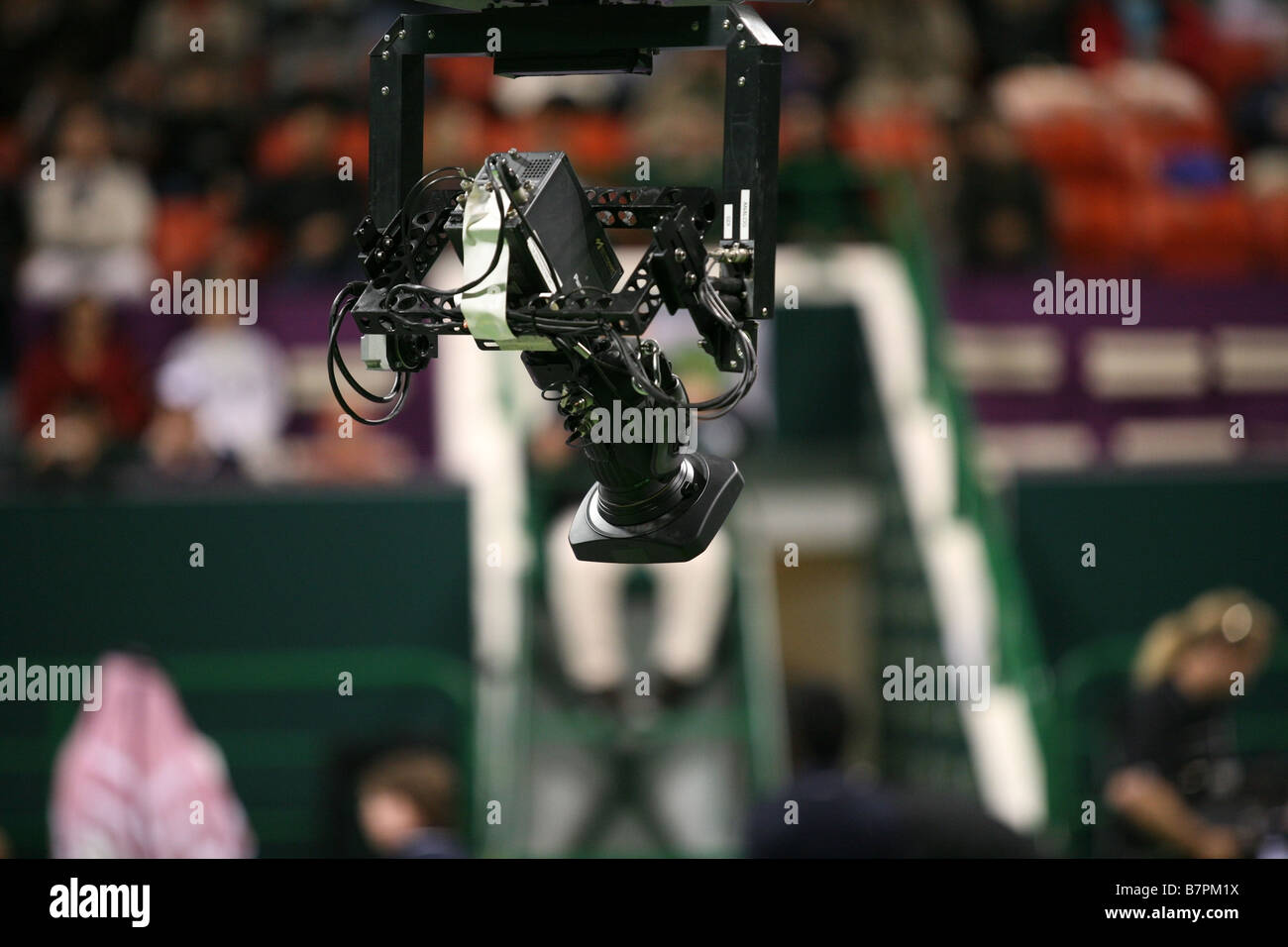 A remote control roving TV camera suspended by wires connected to the ...