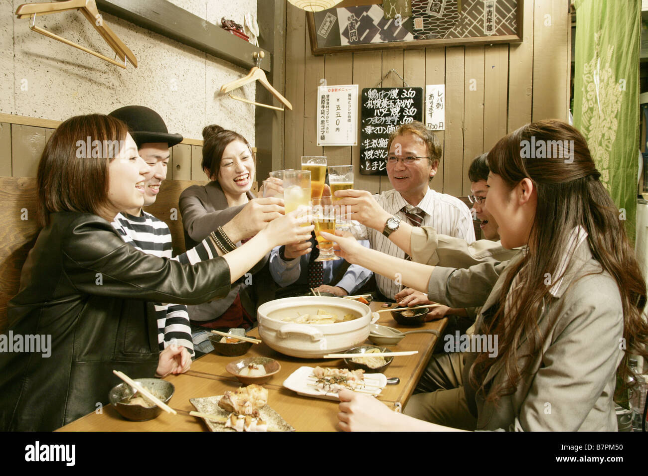 Man and woman making a toast in the Japanese-style pub Stock Photo - Alamy