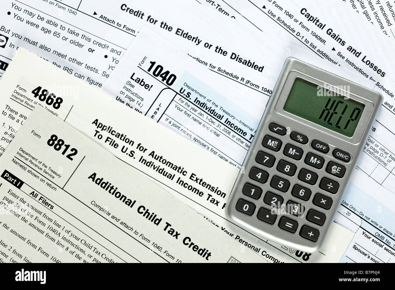 Several tax forms with a calculator that says help Stock Photo - Alamy