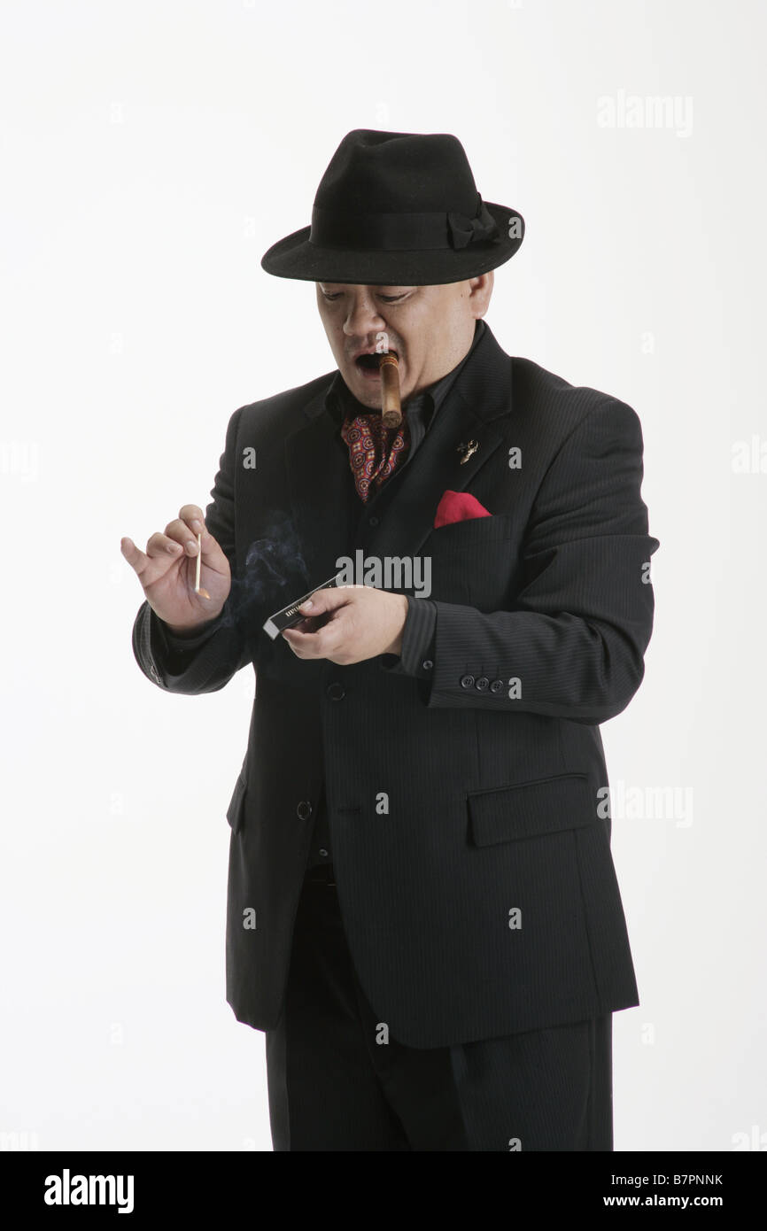 A man in suit smoking a cigar Stock Photo - Alamy