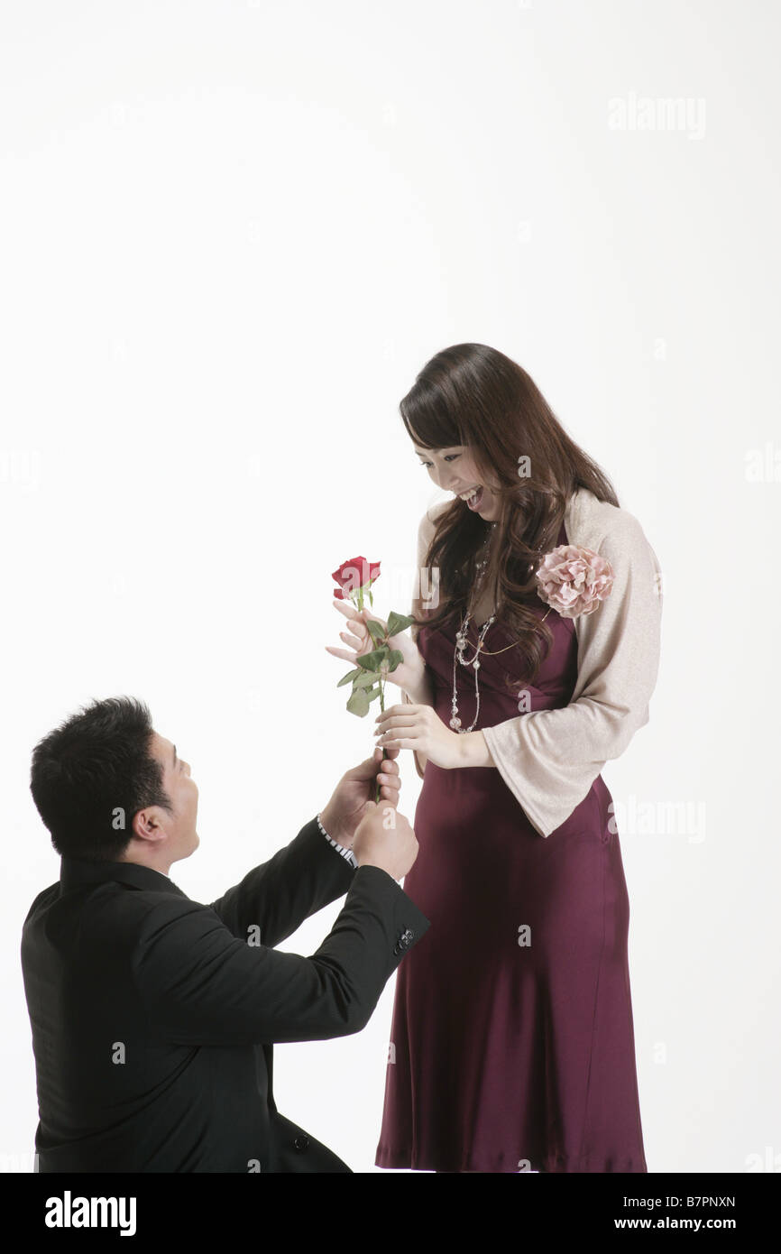 A man presenting flower to a woman Stock Photo - Alamy